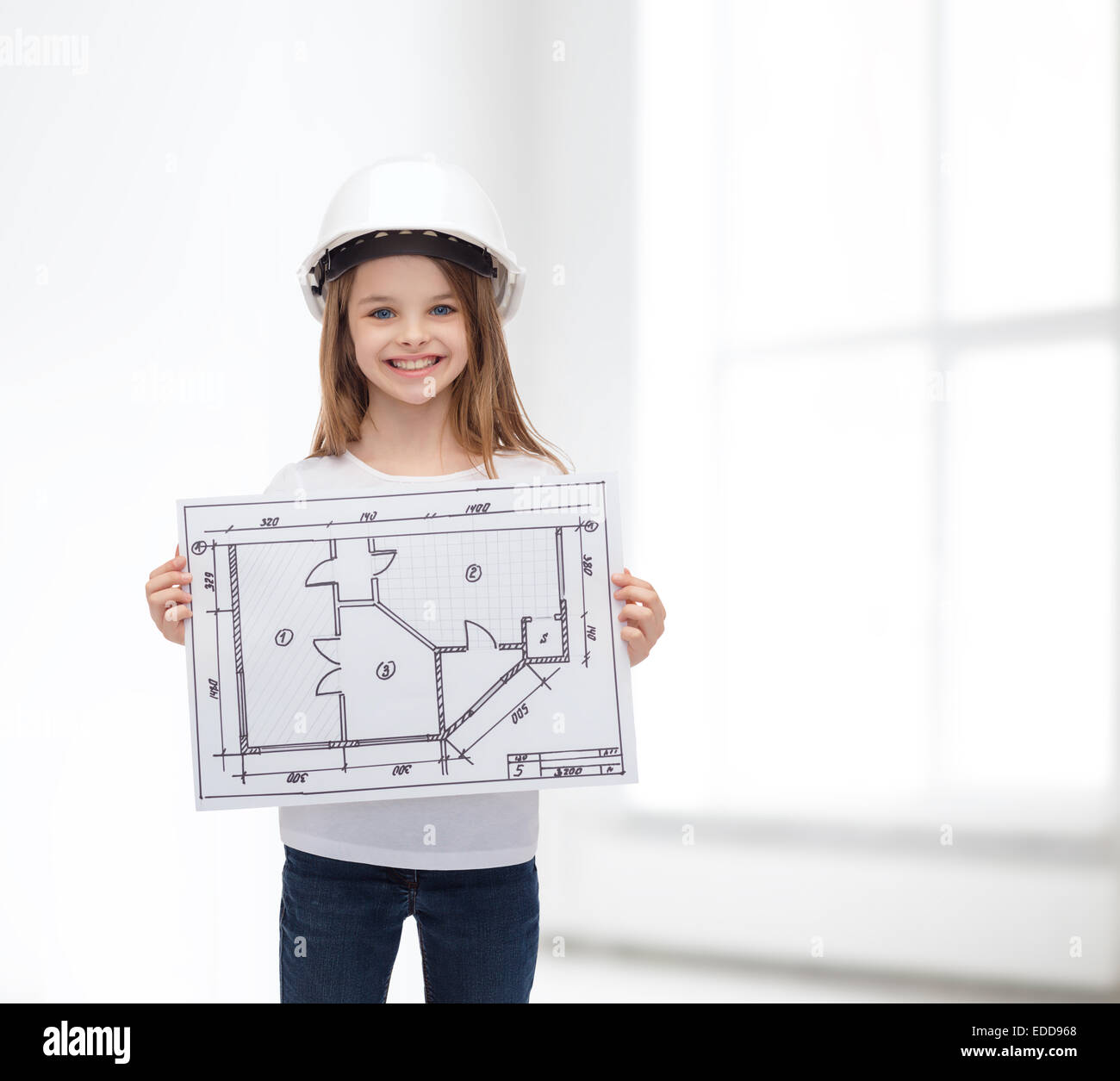 smiling little girl in helmet showing blueprint Stock Photo - Alamy