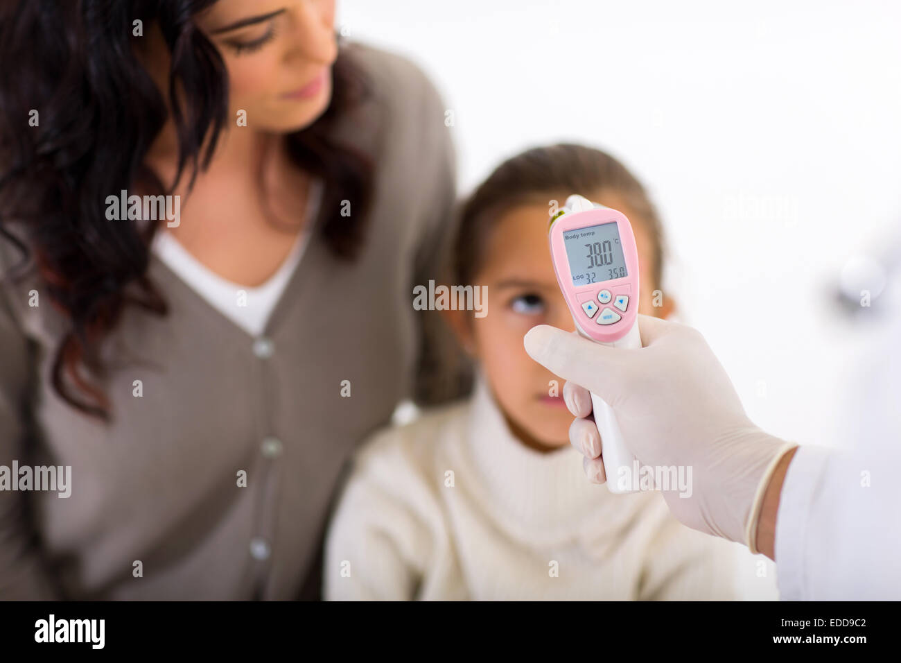 medical doctor checking the body temperature of little patient with a ...