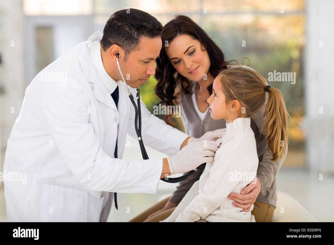 caring medical doctor examining a little girl in office Stock Photo - Alamy