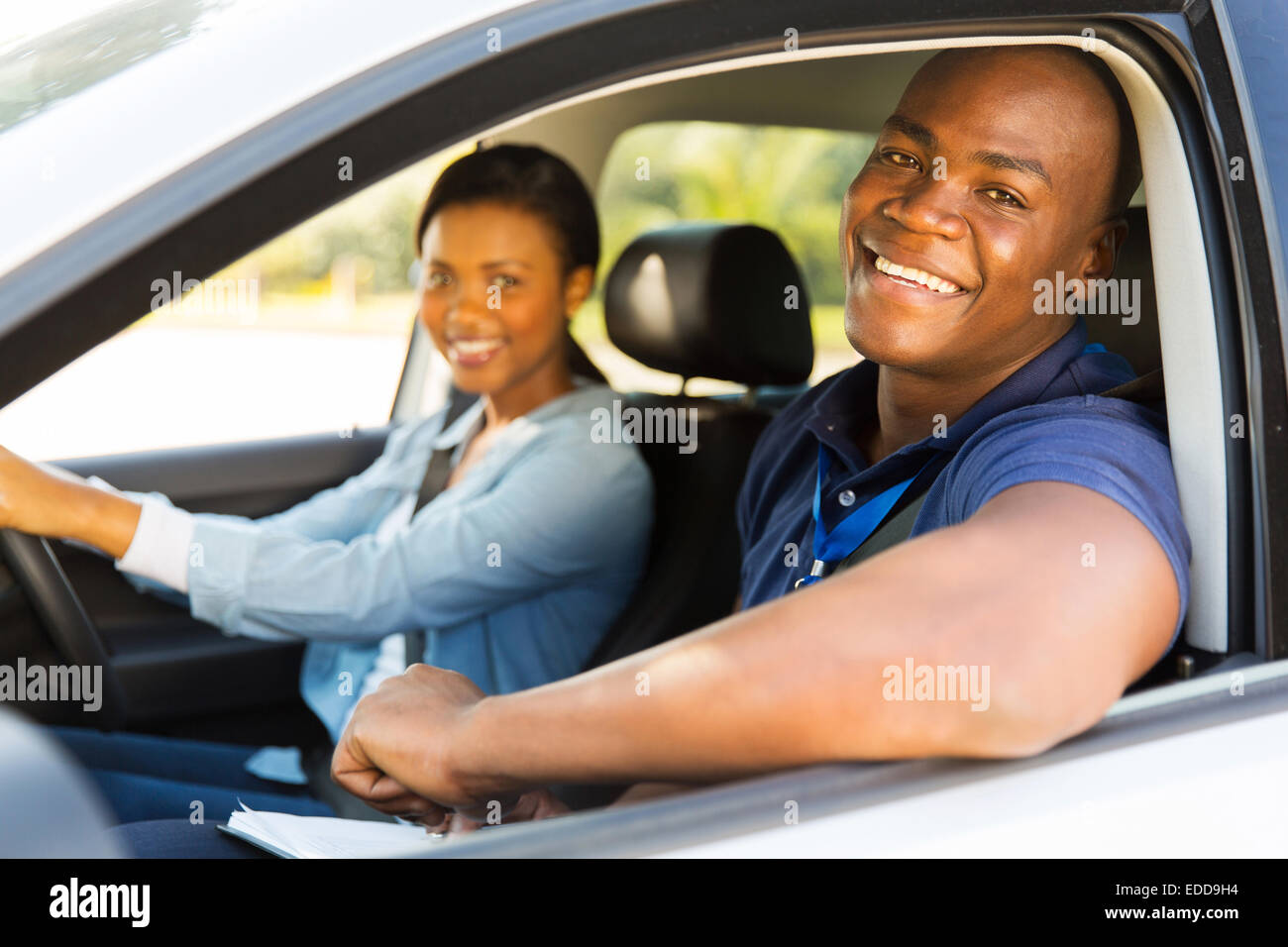 happy male African American driving instructor and student driver ...