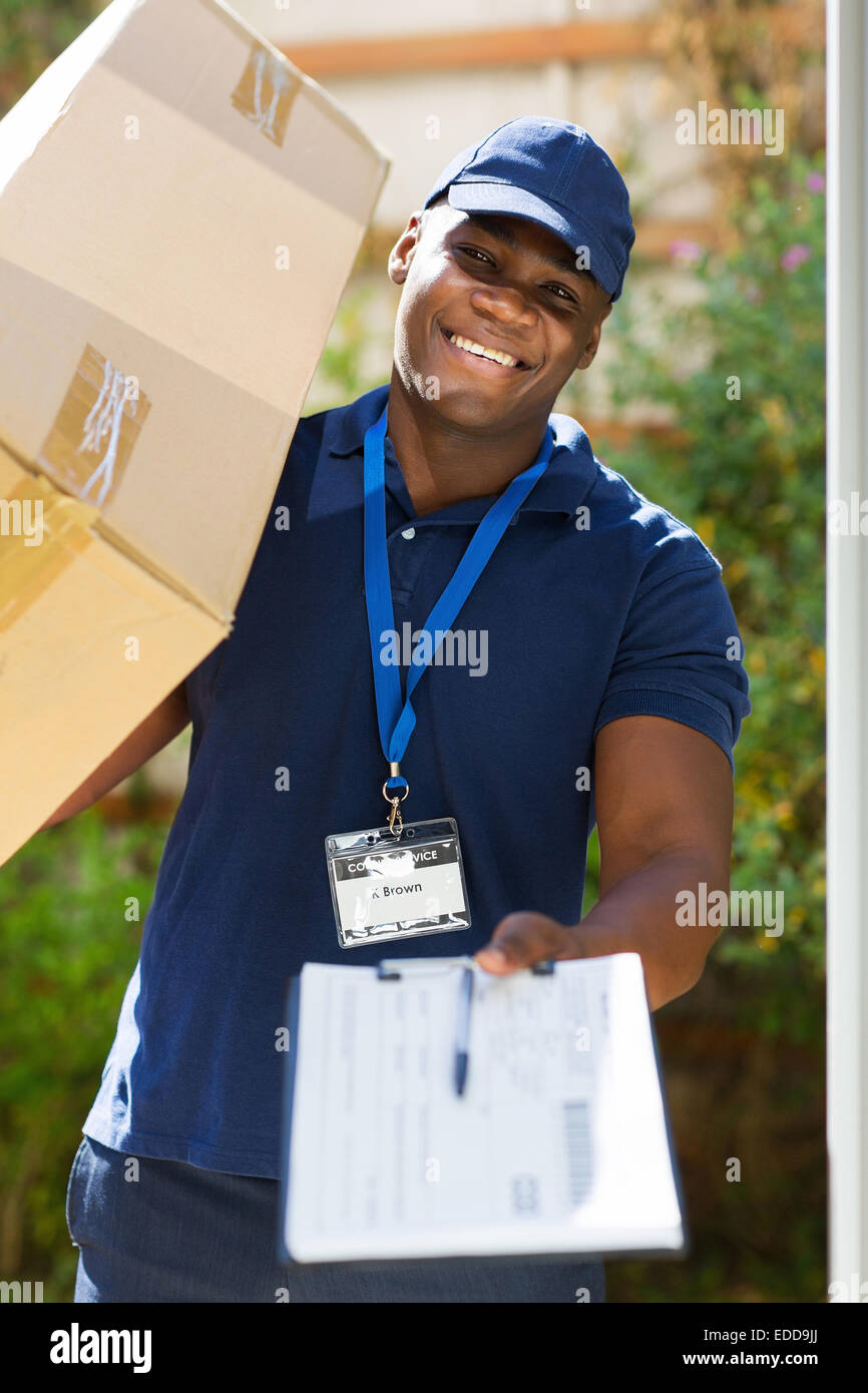 African delivery man carrying parcel and presenting receiving form ...