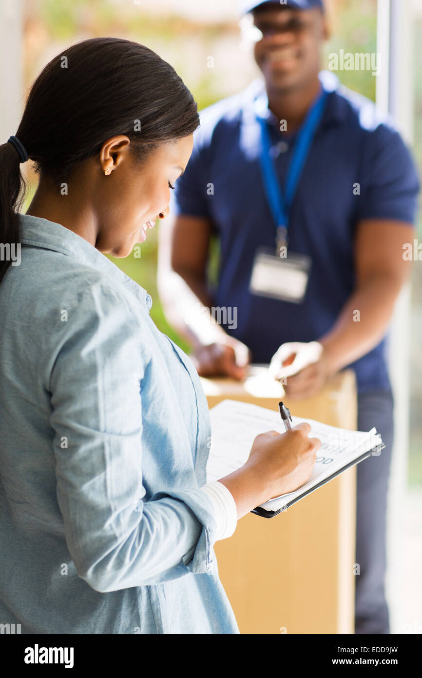 happy African woman receiving post and signing document Stock Photo - Alamy