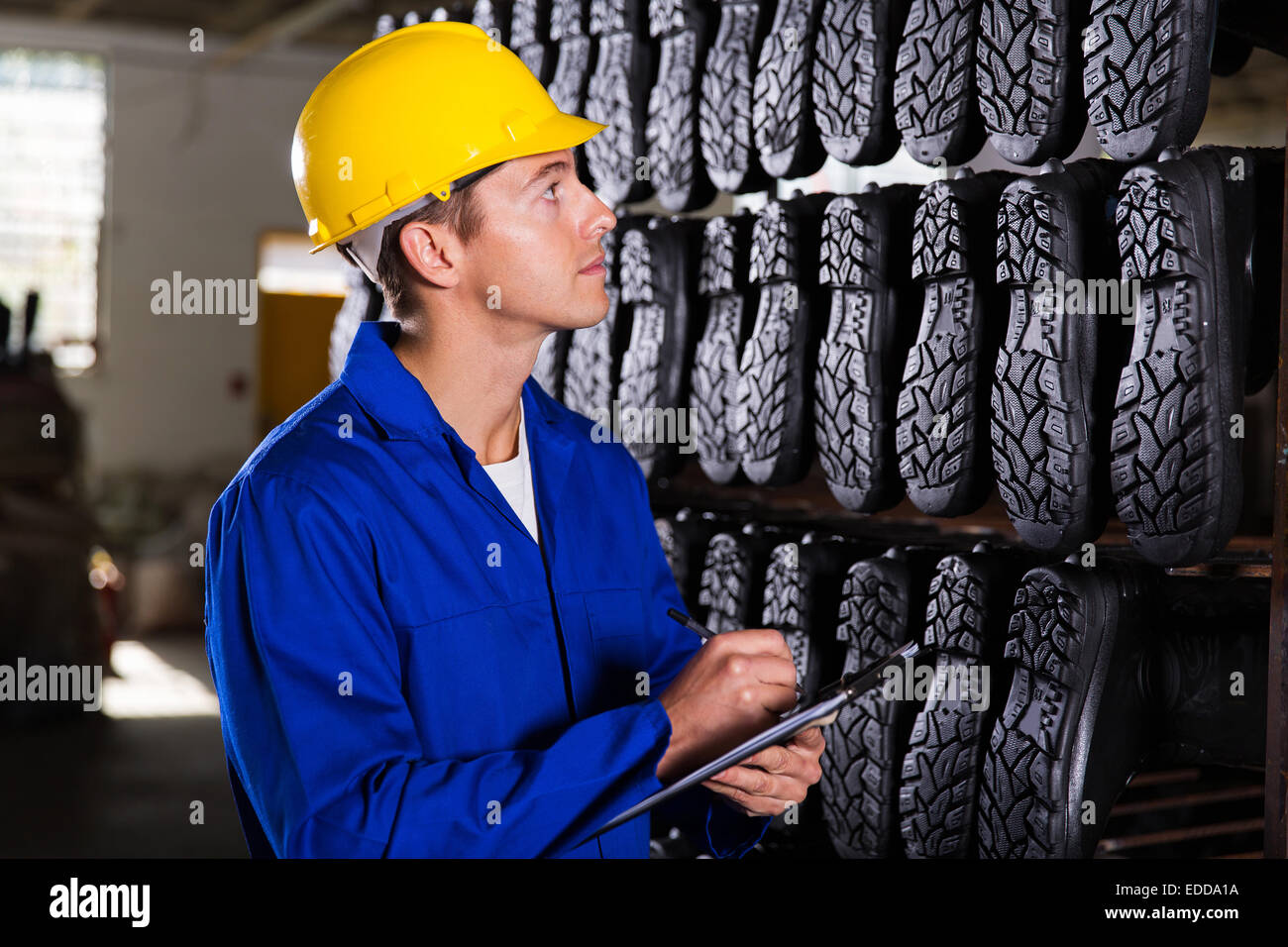 handsome factory worker taking rubber-boots sizes in storeroom Stock ...