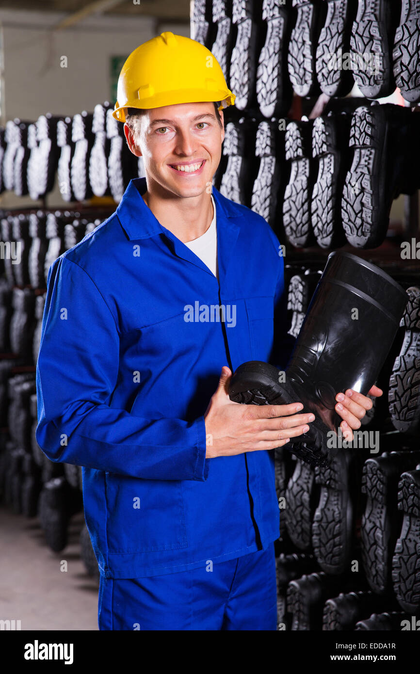 smiling factory worker holding rubber-boot Stock Photo - Alamy