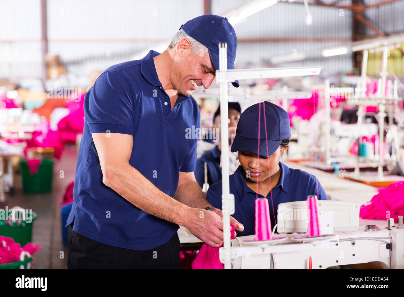 clothing factory quality controller checking stitch on production line ...