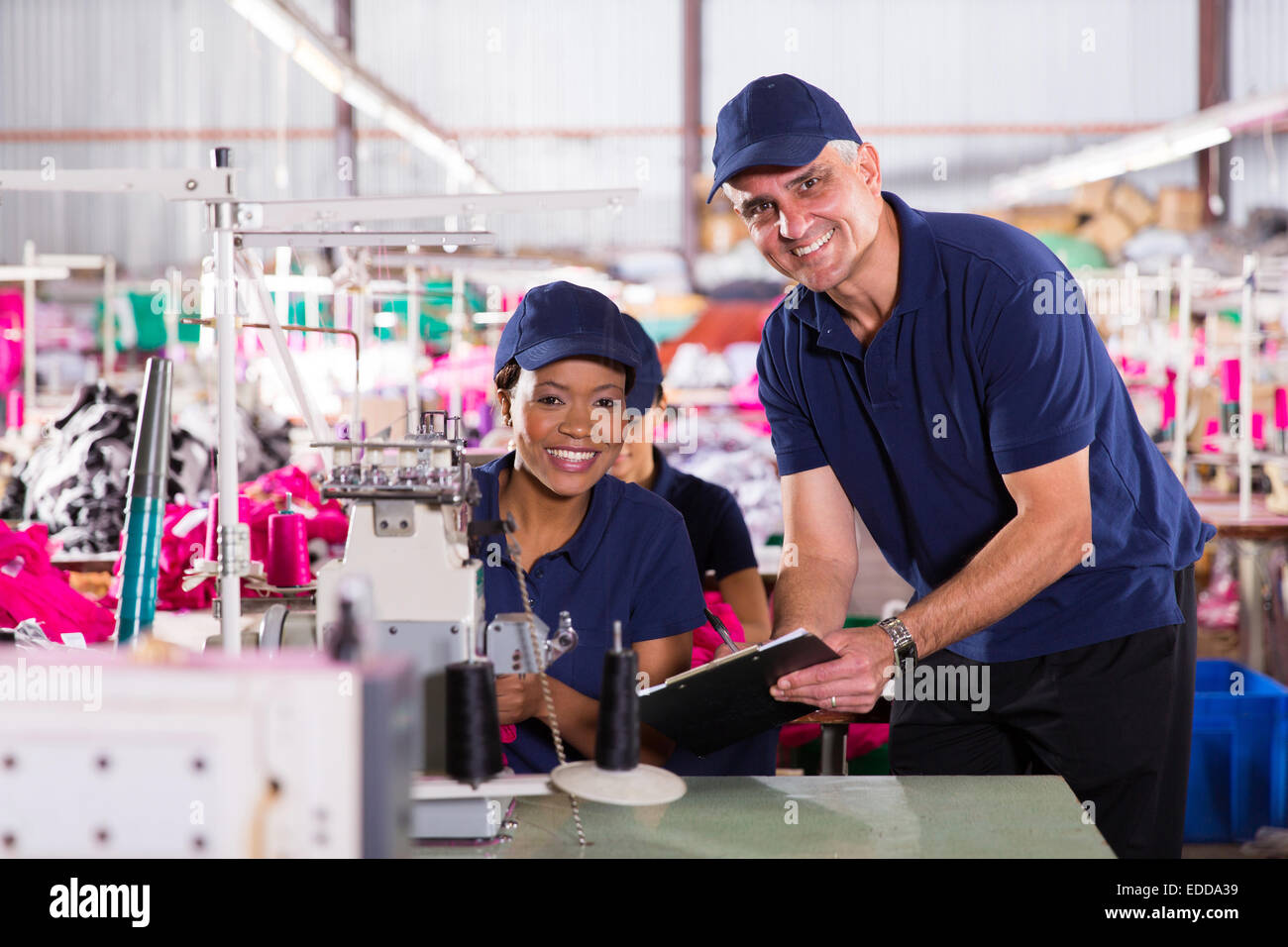 portrait of African machinist with senior foreman in clothing factory ...