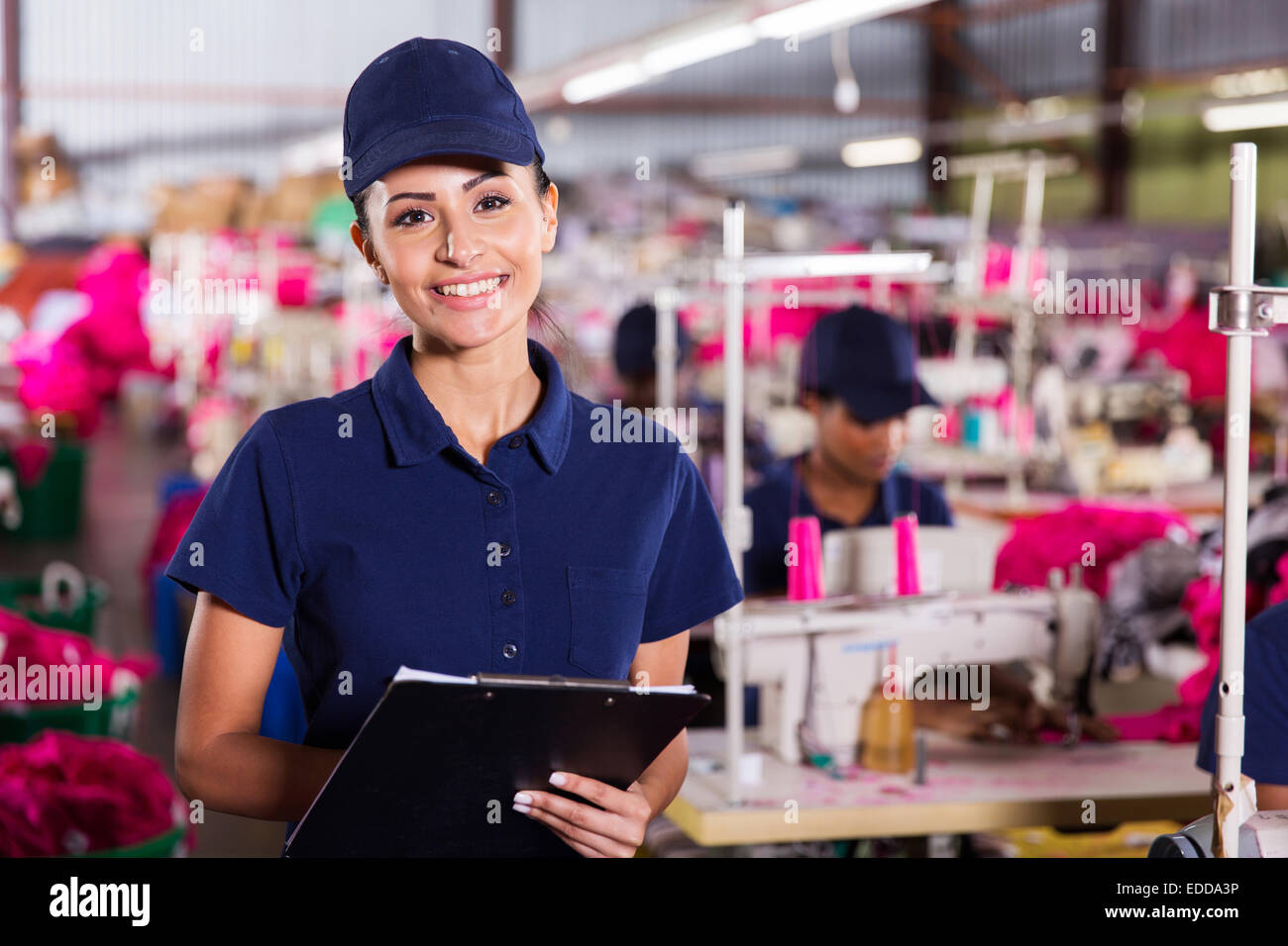 portrait of pretty female textile worker holding clipboard Stock Photo ...