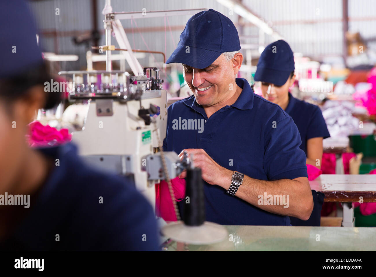 happy senior machinist sewing in clothing factory Stock Photo - Alamy