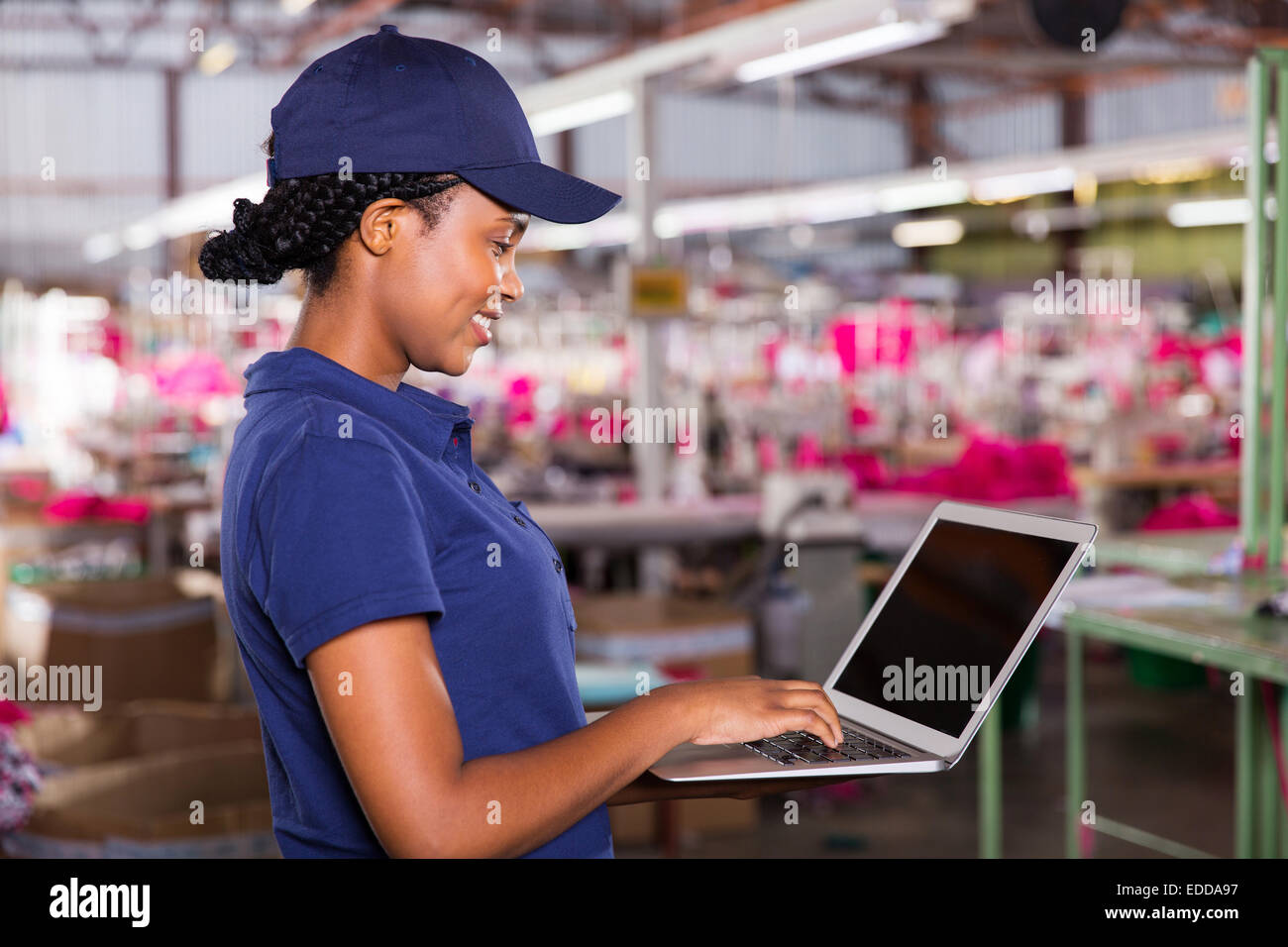 side view of clothing factory manager using laptop computer Stock Photo ...