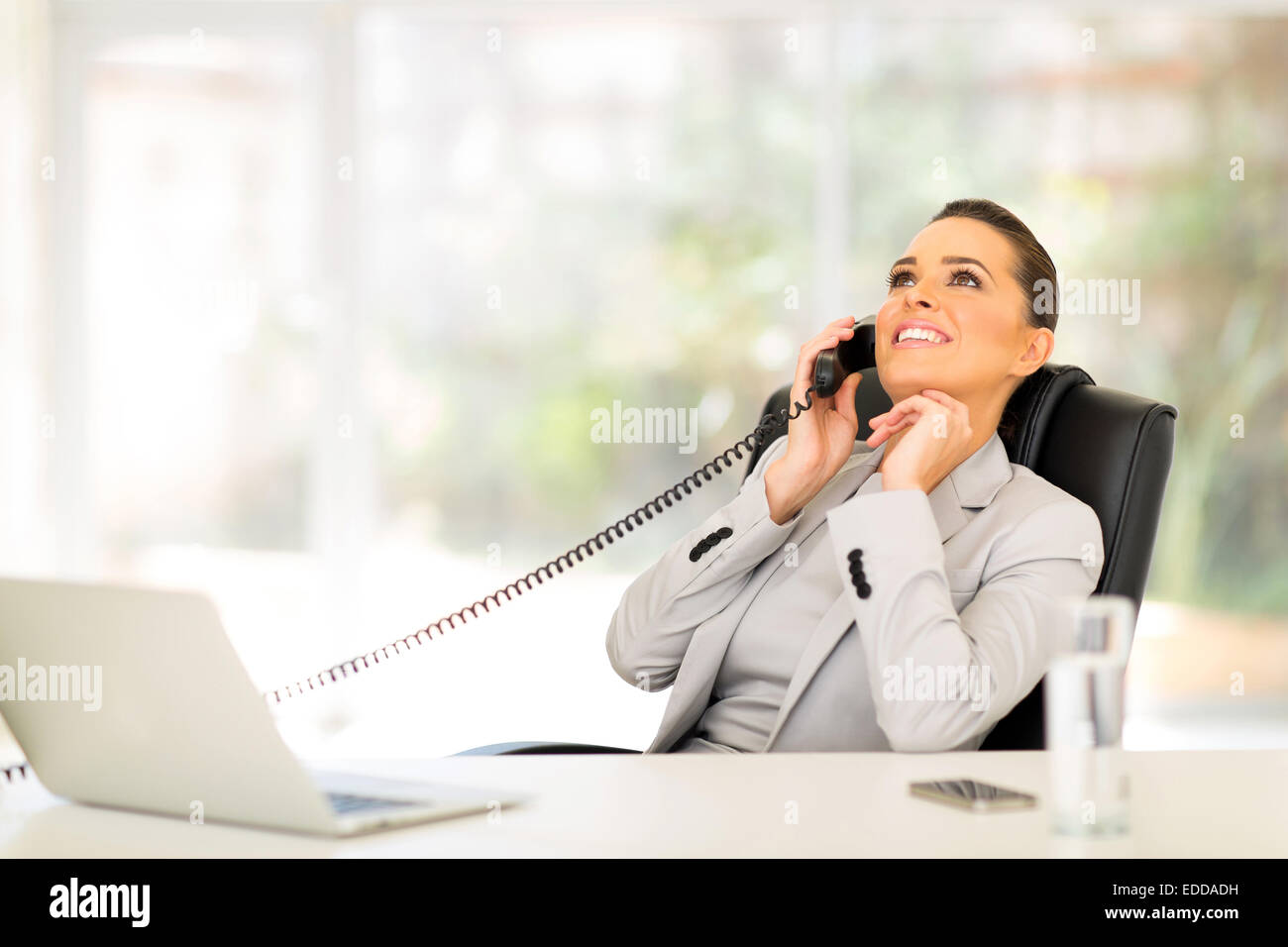 relaxed businesswoman using telephone in office Stock Photo - Alamy