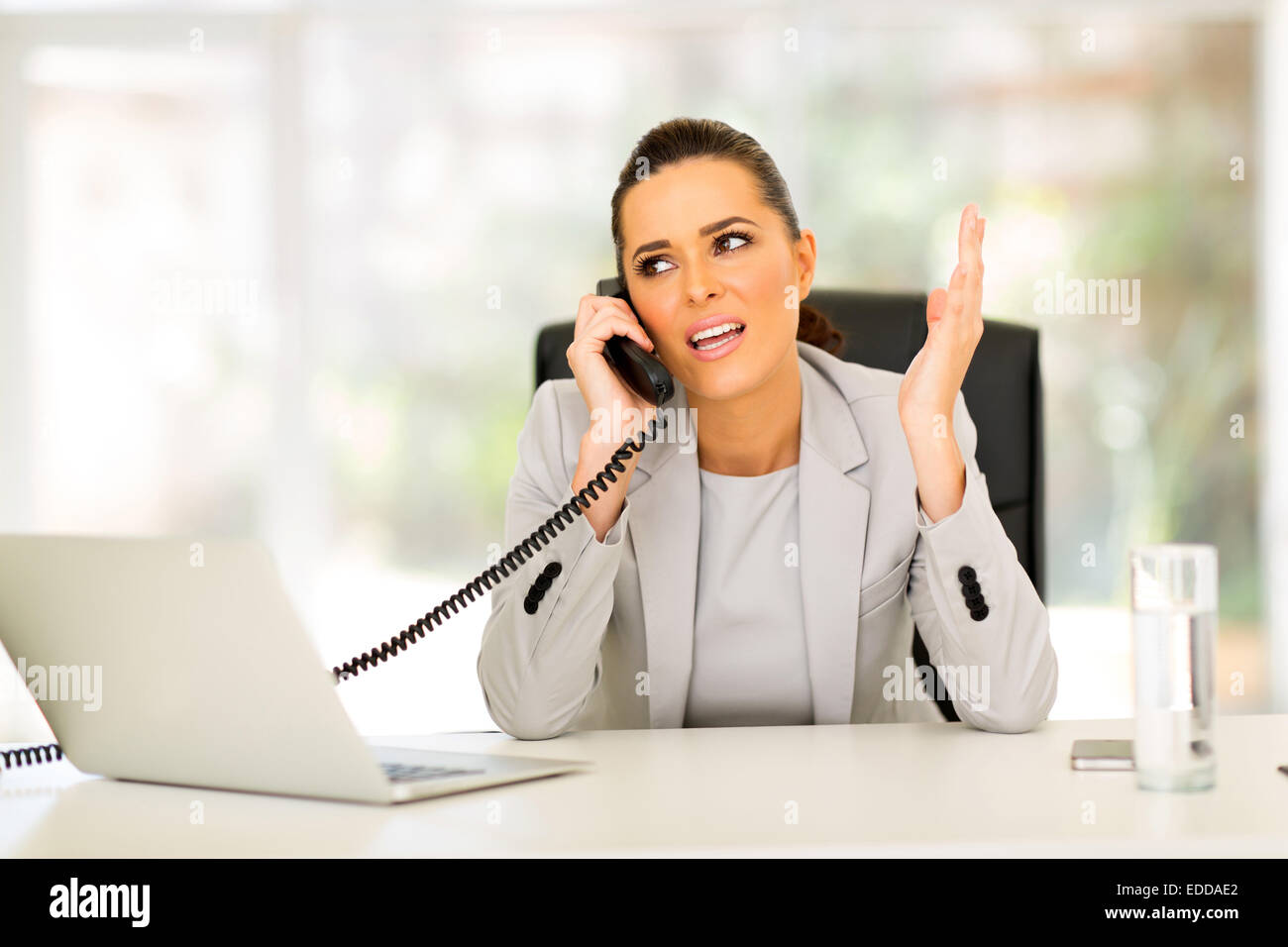 confused office worker talking on landline phone Stock Photo - Alamy