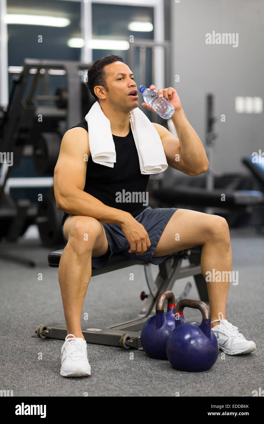 mid age man drinking water after exercise in fitness gym Stock Photo ...