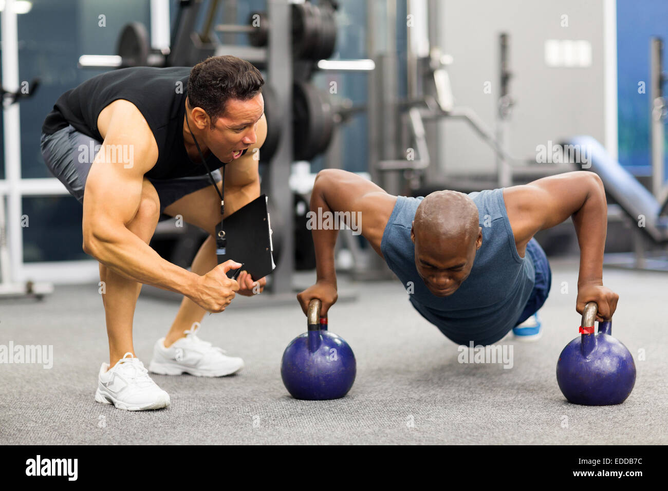 personal trainer motivates client doing push-ups in gym Stock Photo - Alamy