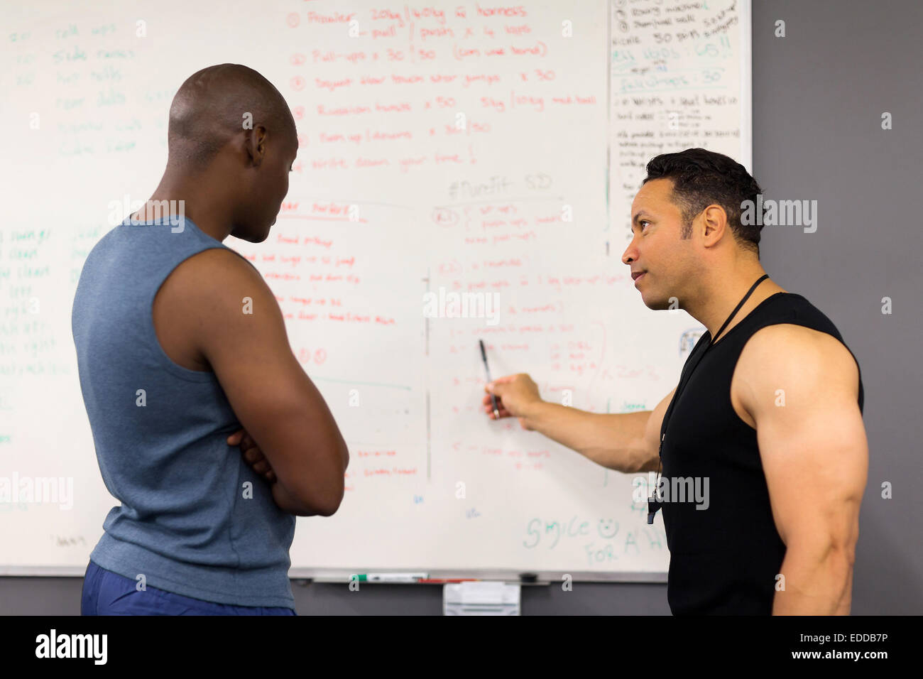 professional personal trainer teaching man in fitness classroom Stock ...