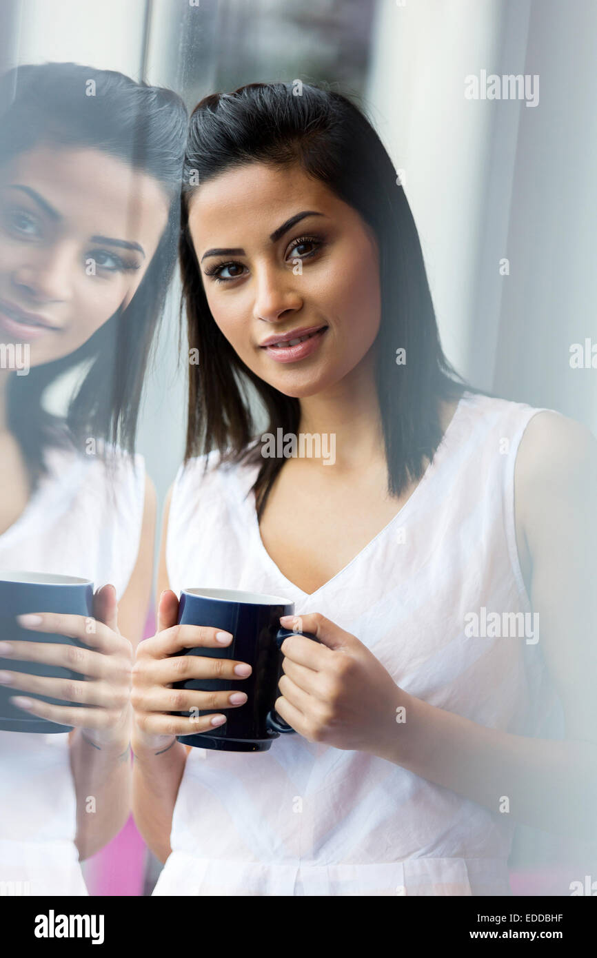 gorgeous woman having coffee in front of window Stock Photo - Alamy