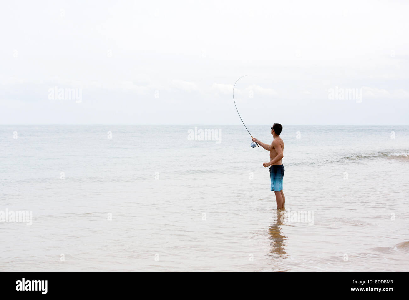young man fly fishing on beach Stock Photo - Alamy