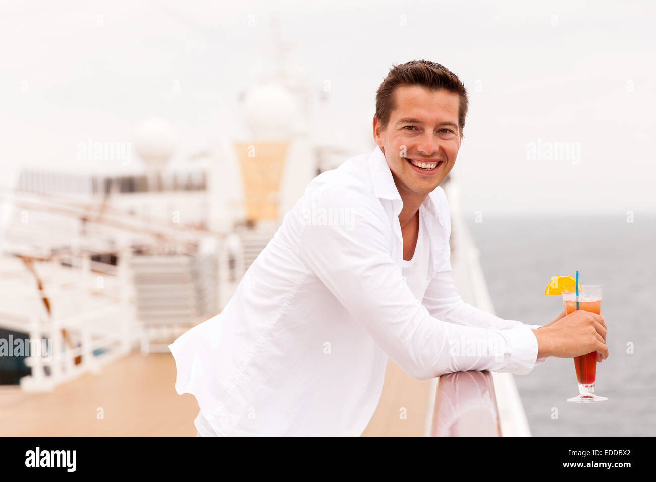 handsome young man drinking cocktail on cruise ship Stock Photo - Alamy
