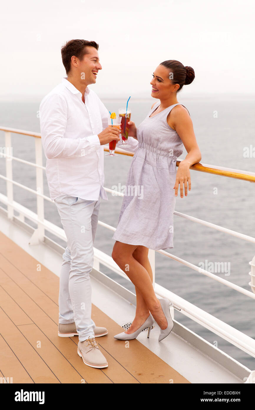 Relaxed Young Couple Having Cocktail Drinks On Cruise Ship Deck Stock