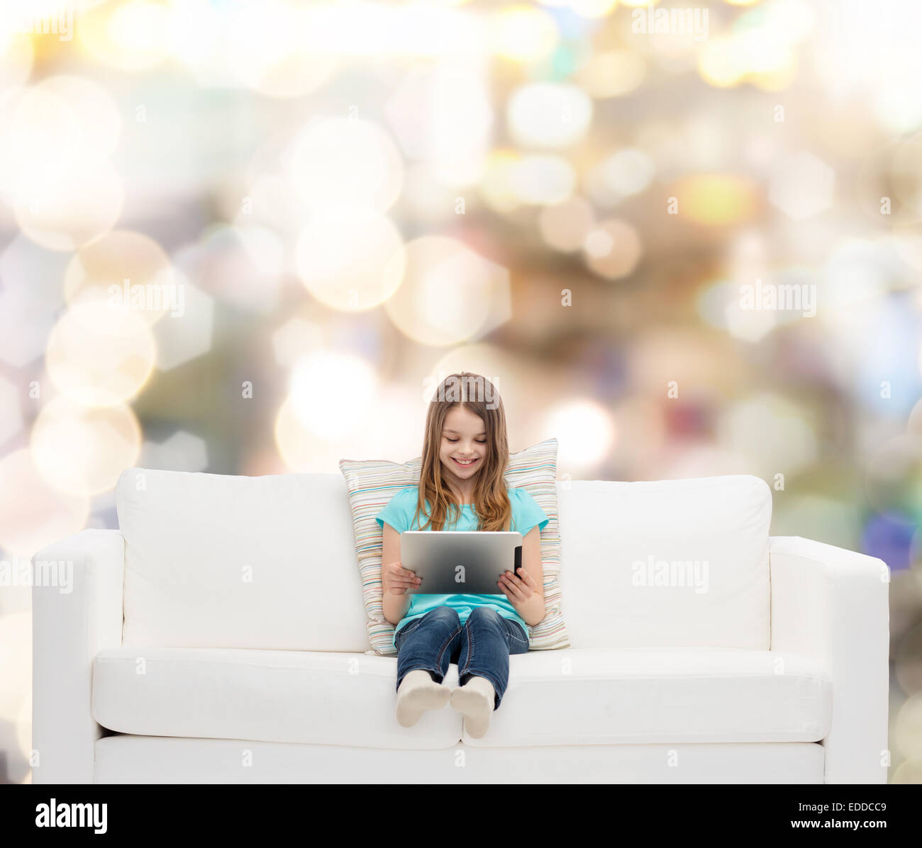 little girl sitting on sofa with tablet pc Stock Photo - Alamy