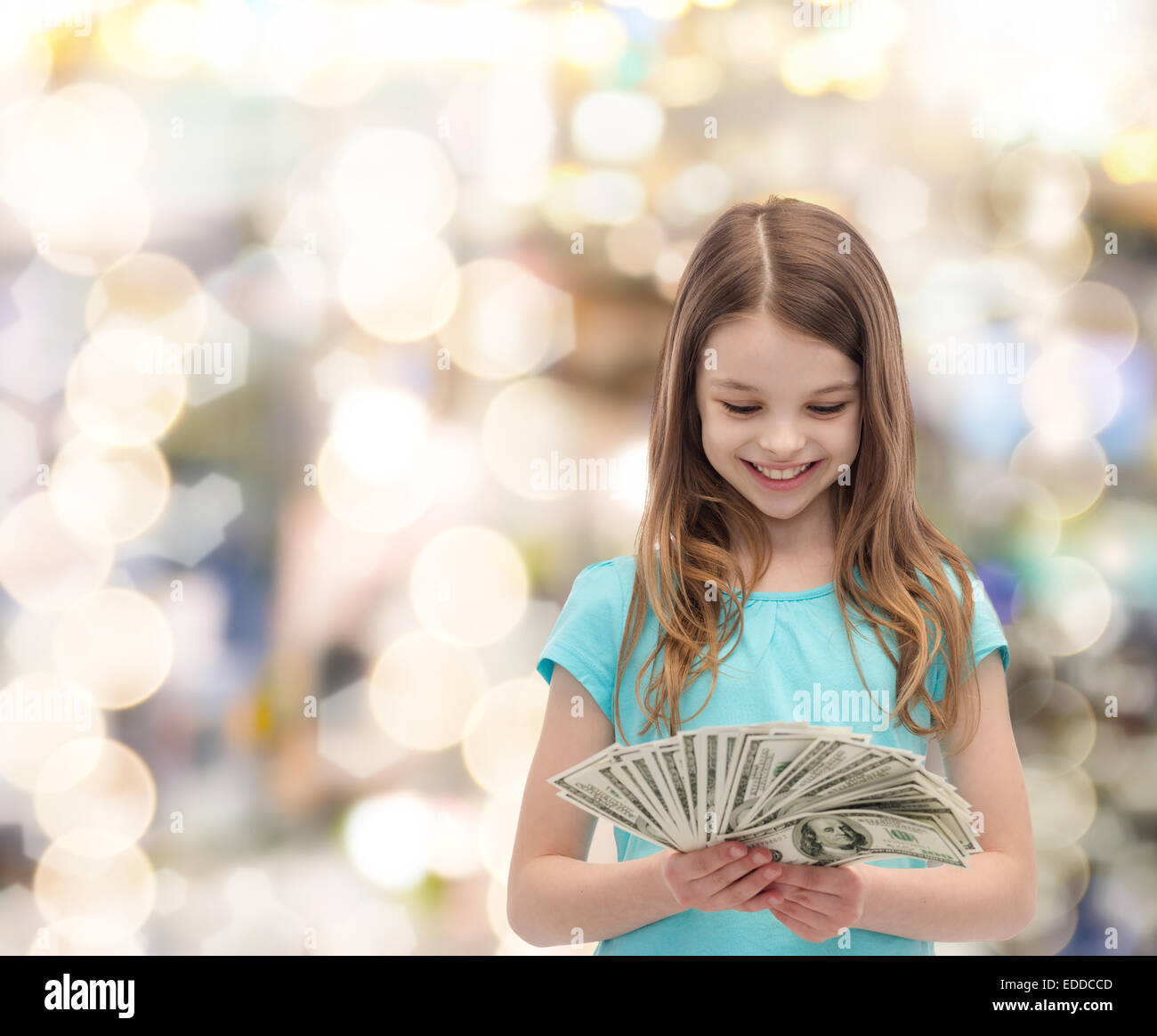 smiling little girl looking at dollar cash money Stock Photo - Alamy
