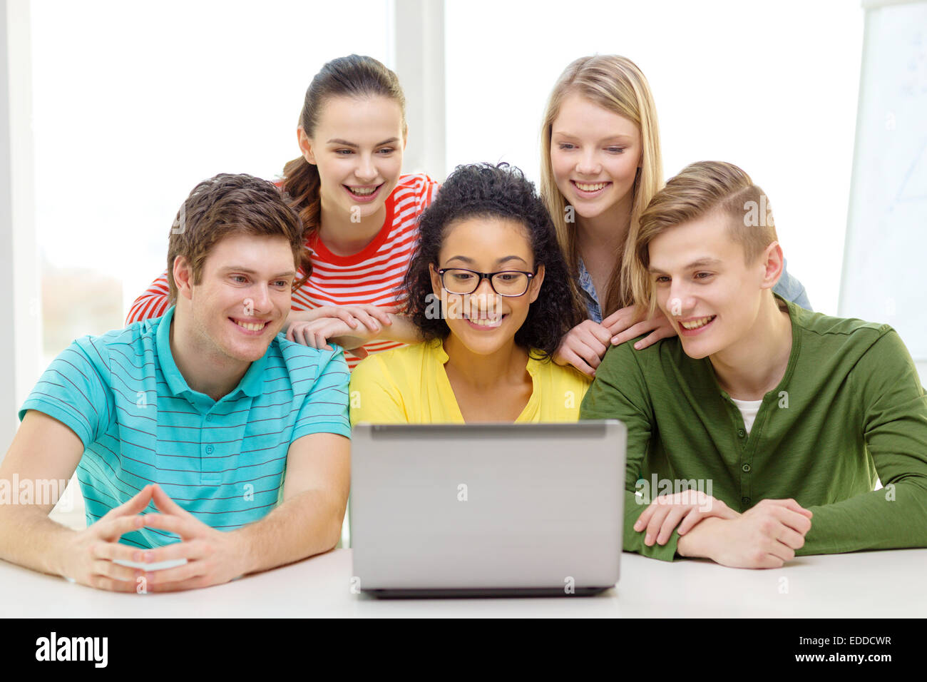 smiling students looking at laptop at school Stock Photo - Alamy