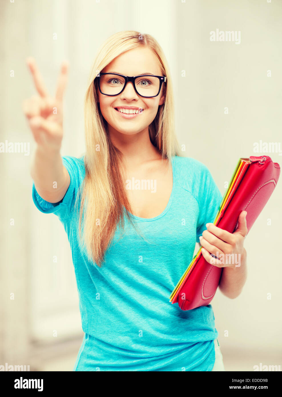 smiling student with folders showing victory sign Stock Photo - Alamy