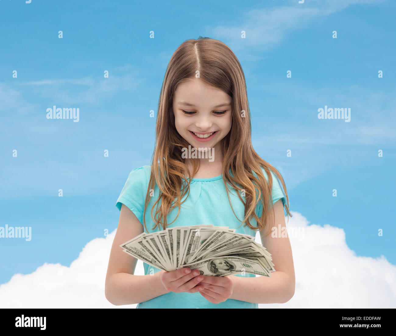 smiling little girl looking at dollar cash money Stock Photo - Alamy