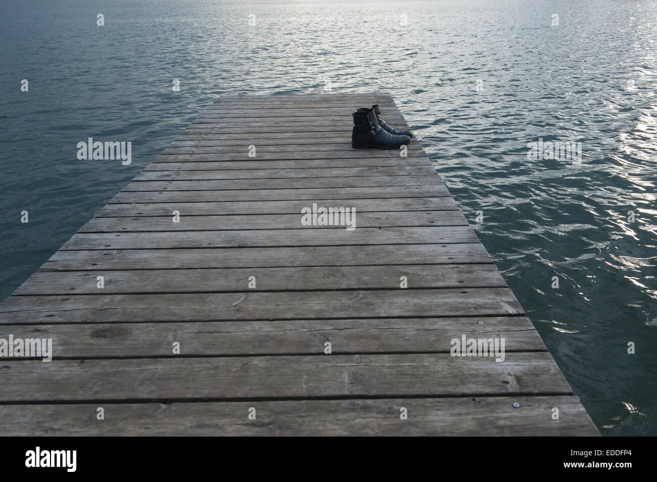 Pair of boots standing on wooden boardwalk at lake Stock Photo - Alamy