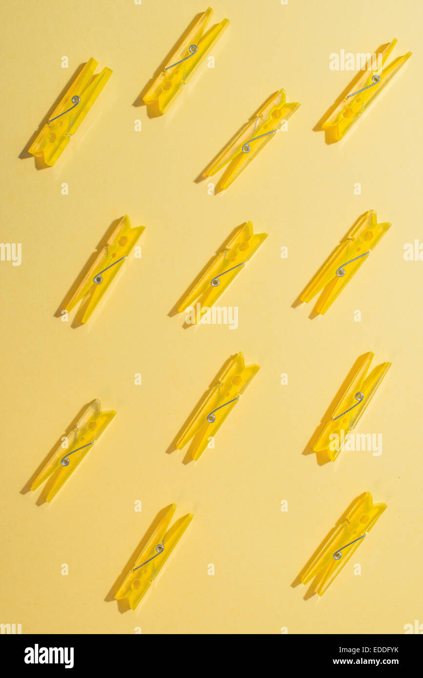 Clothes pegs on yellow background Stock Photo - Alamy