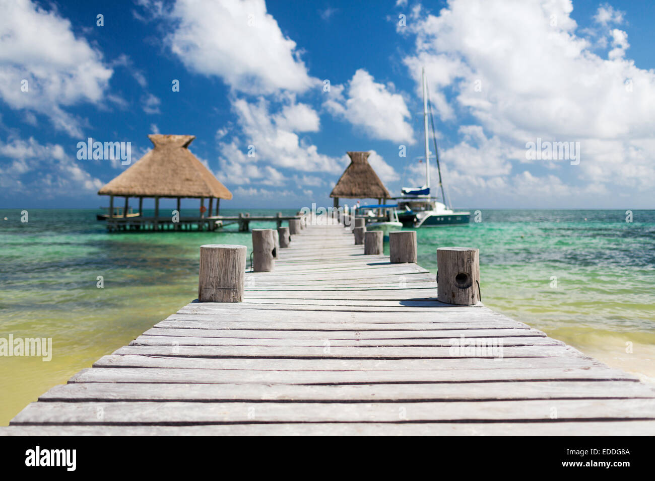 wooden pier with blue water around Stock Photo - Alamy