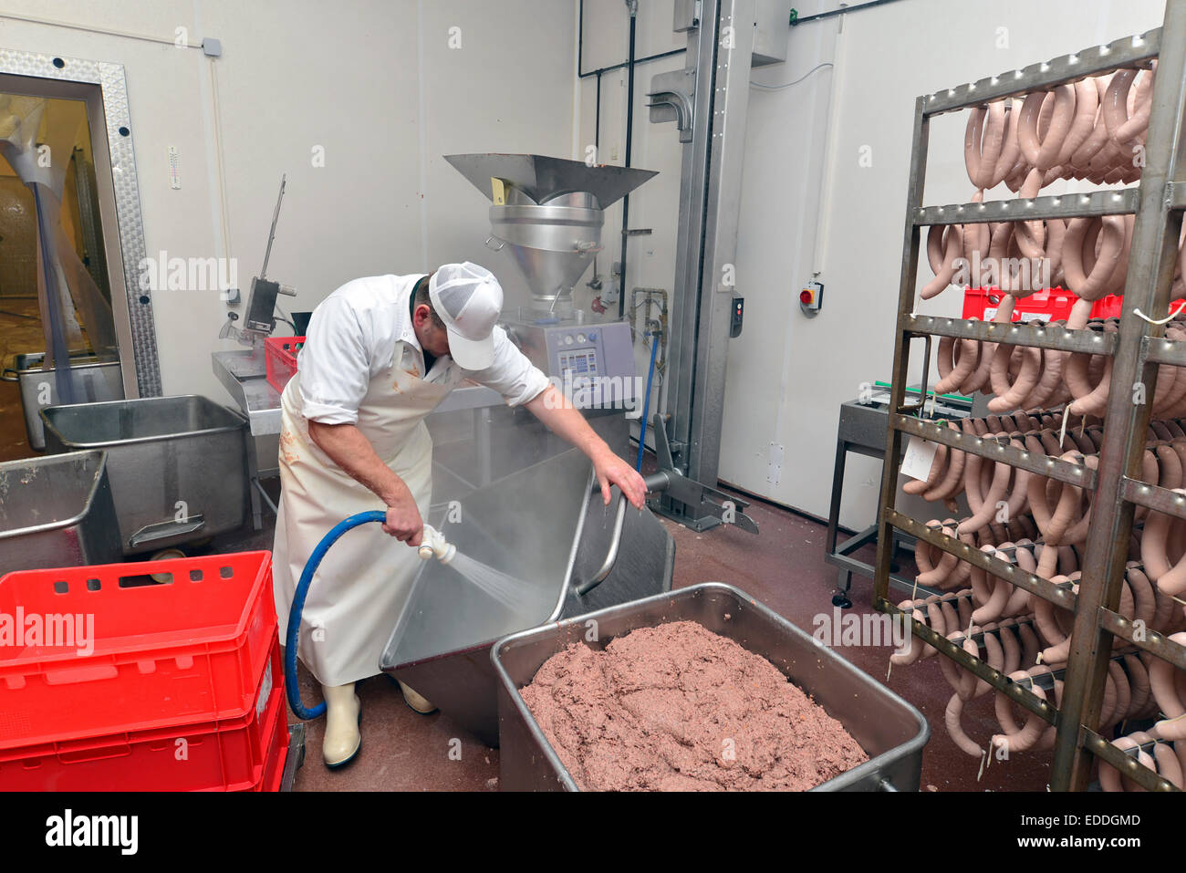 Man cleaning container with sausage meat in a butchery Stock Photo - Alamy