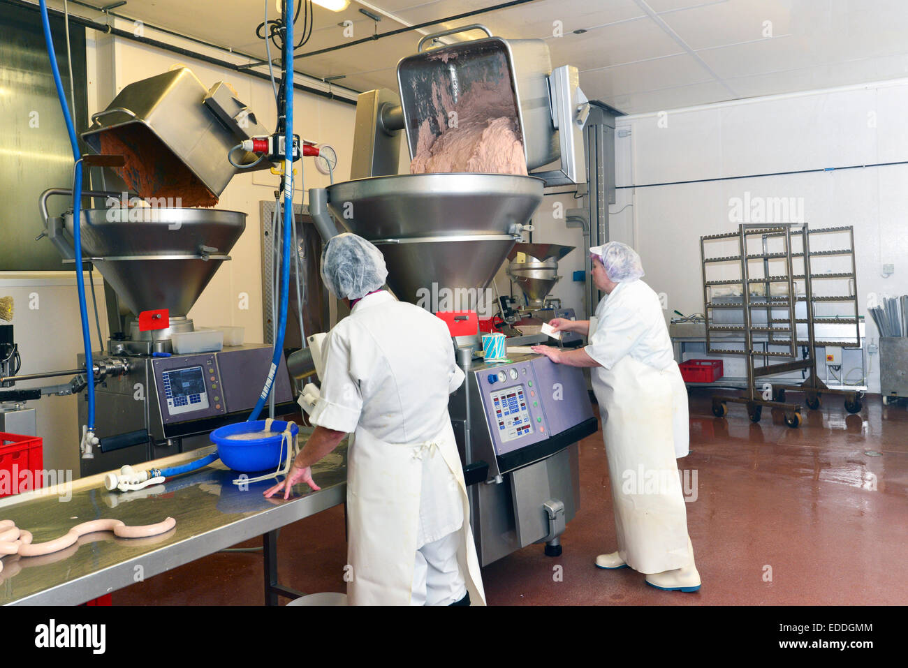 Woman operating filling machine with meat sausage in a butchery Stock ...