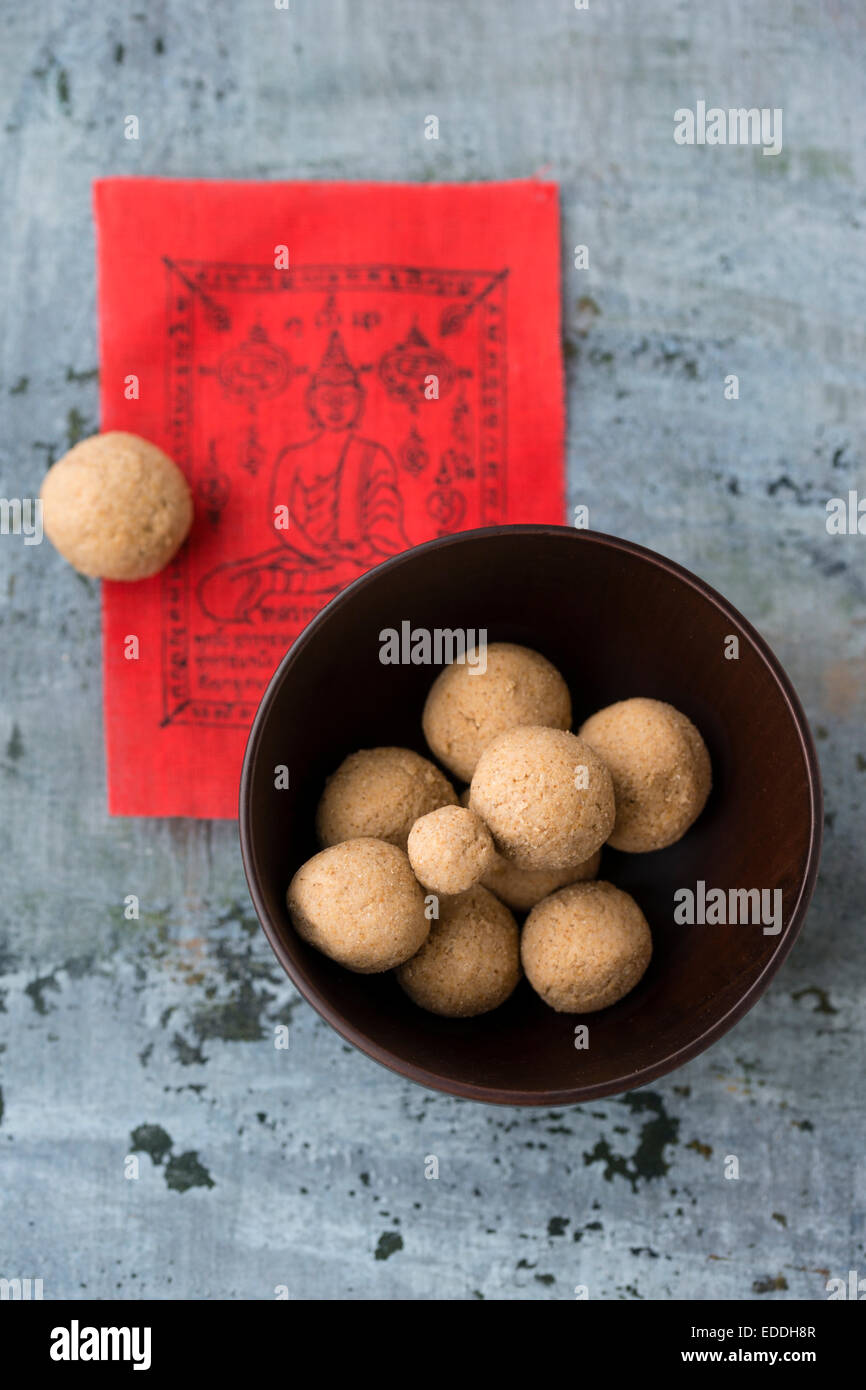 Bowl of Tsampa balls and red prayer flag on grey ground Stock Photo - Alamy