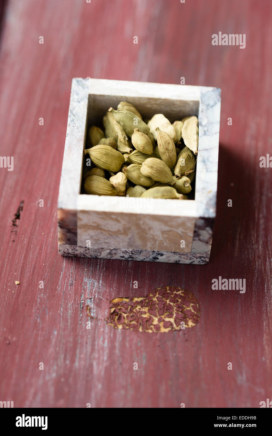 Little box of cardamom capsules on wood Stock Photo - Alamy