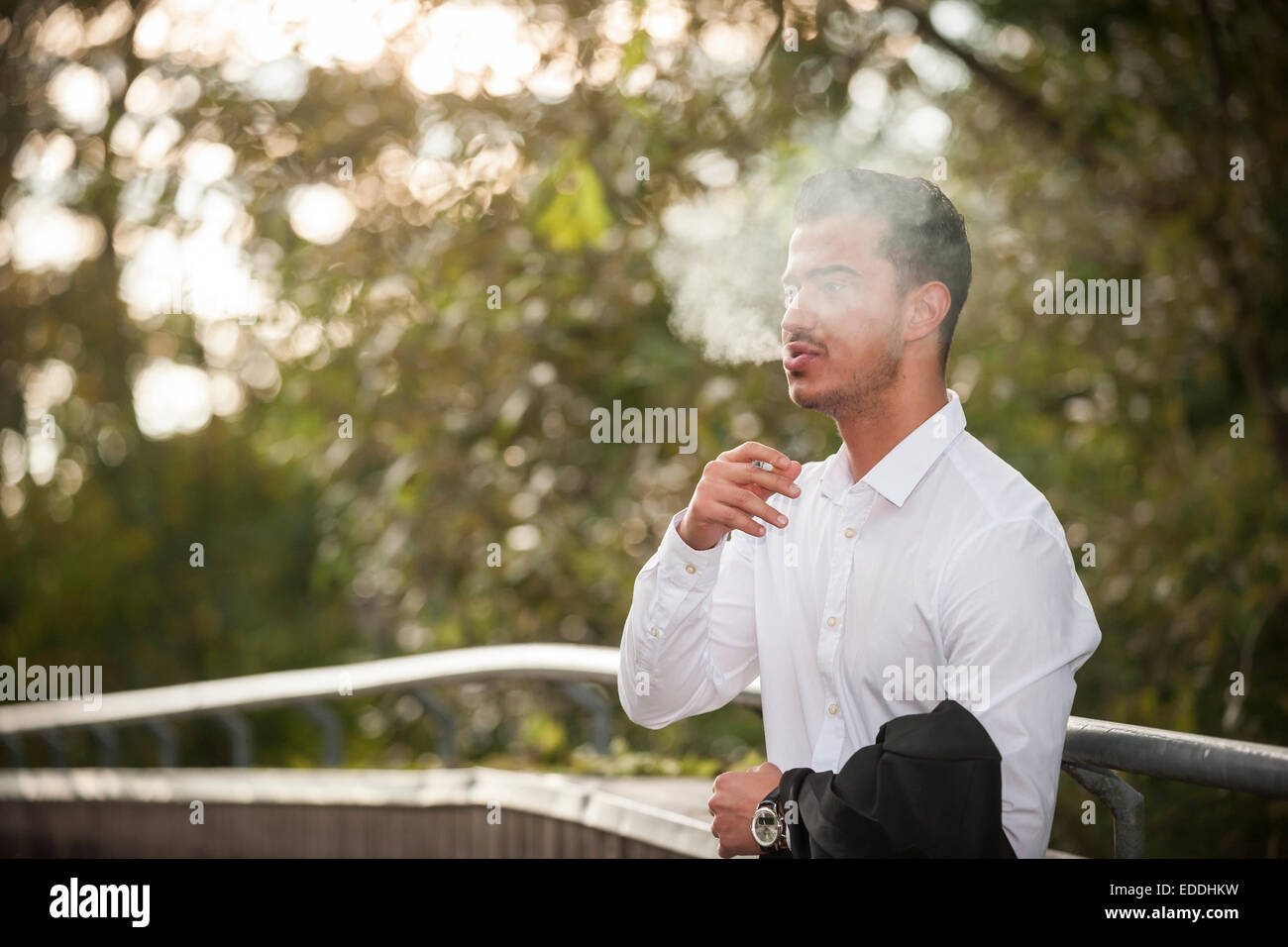 Stylish young man smoking a cigarette Stock Photo - Alamy