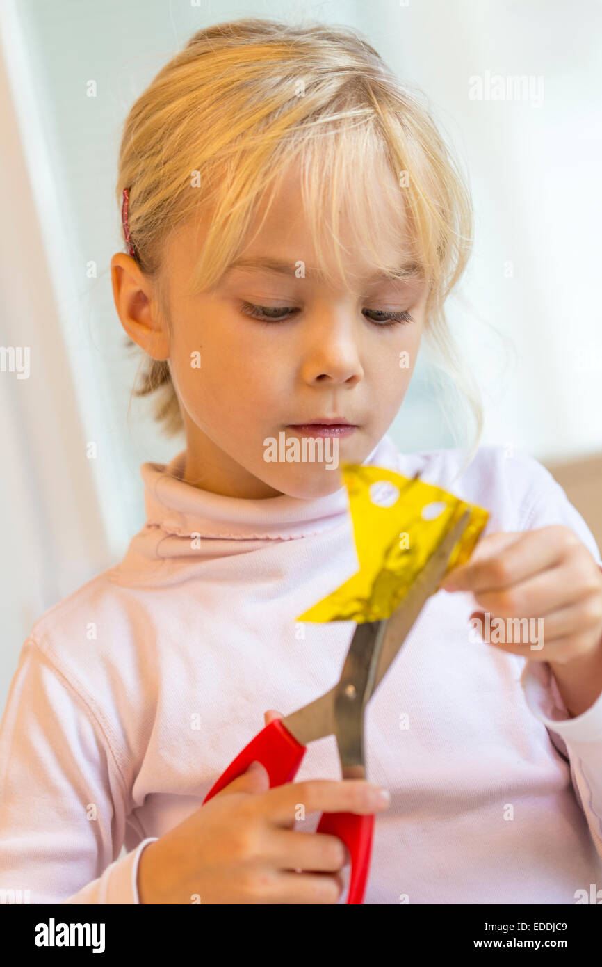 Little girl tinkering with scissors and paper Stock Photo - Alamy