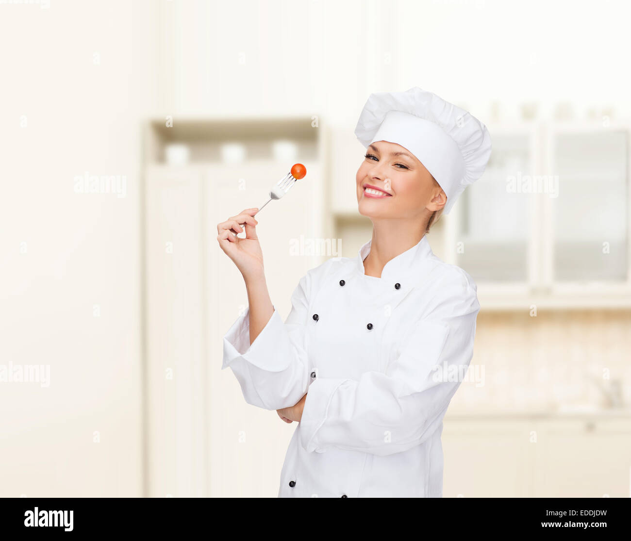 smiling female chef with fork and tomato Stock Photo - Alamy