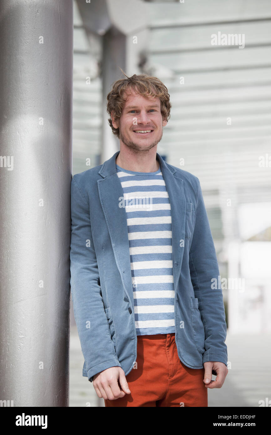 Portrait of smiling man leaning at column Stock Photo - Alamy