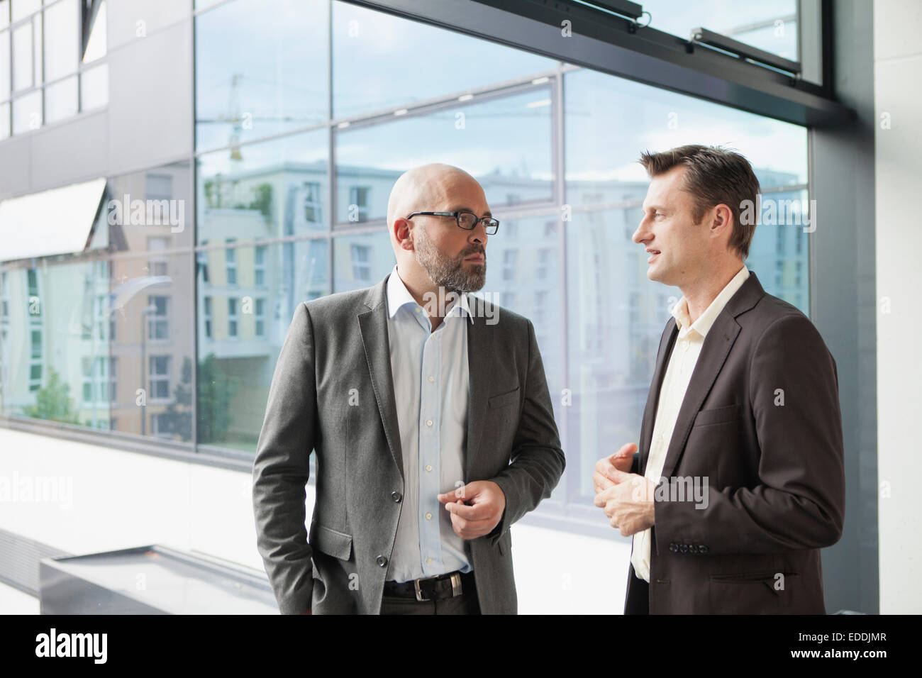 Two businessmen talking in office Stock Photo - Alamy
