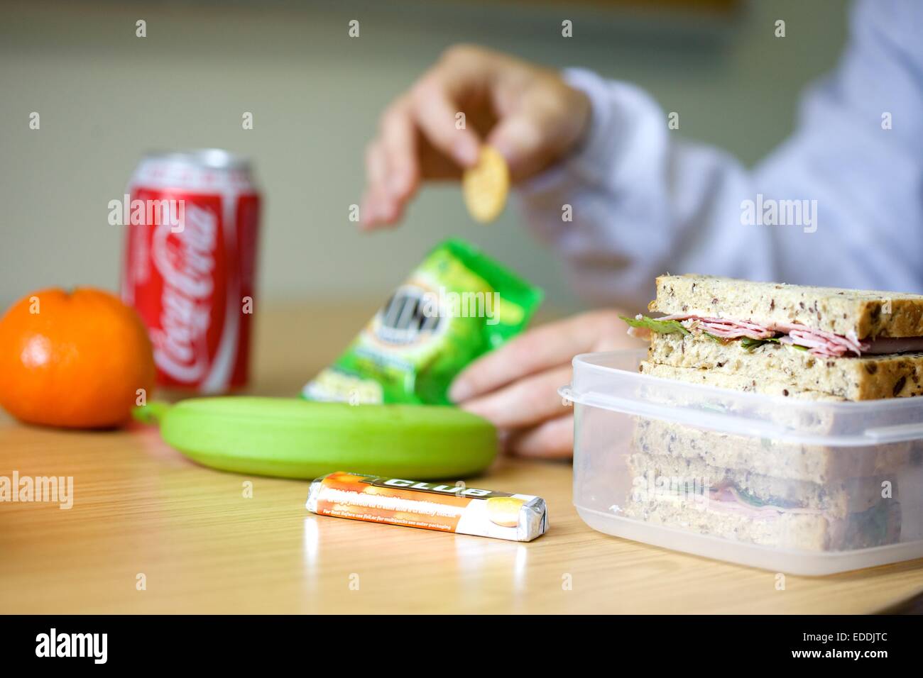 Man enjoying a pack lunch with sandwiches coca-cola orange banana and ...