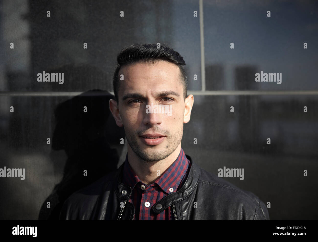 Portrait of man at sunlight in front of dark background Stock Photo - Alamy