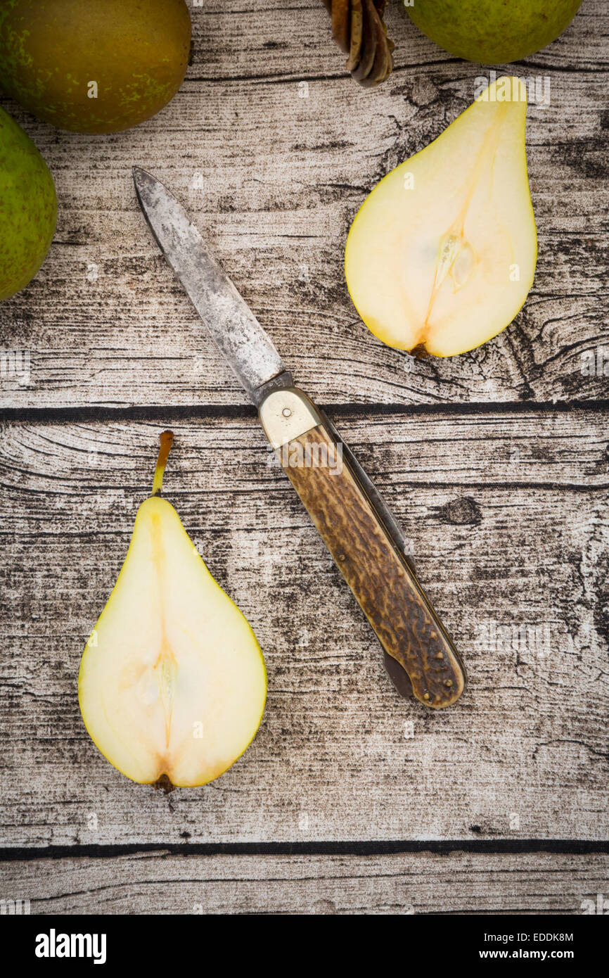 Two halves of organic pear and a pocket knife on grey wood Stock Photo ...