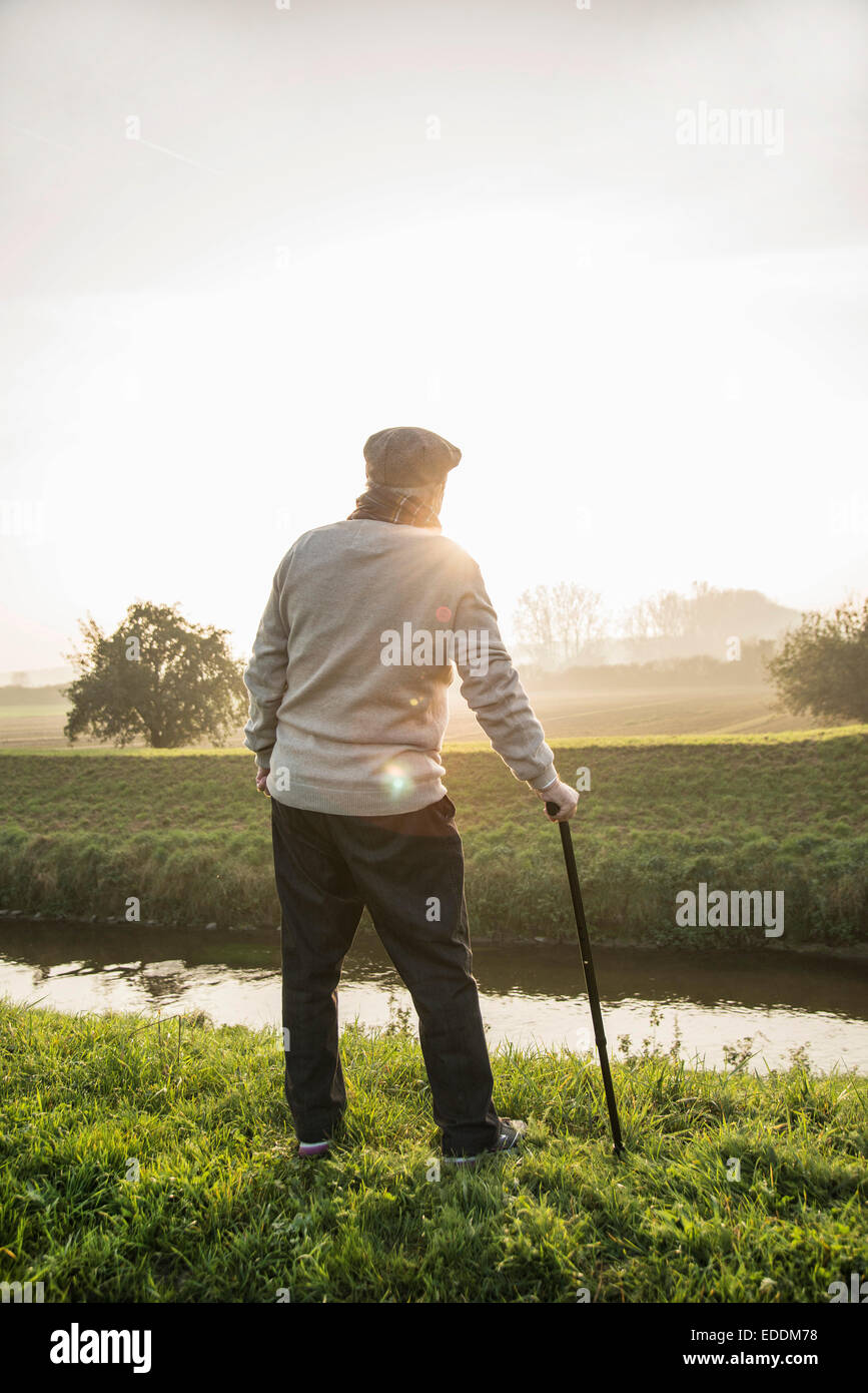 Senior man standing in rural landscape Stock Photo - Alamy