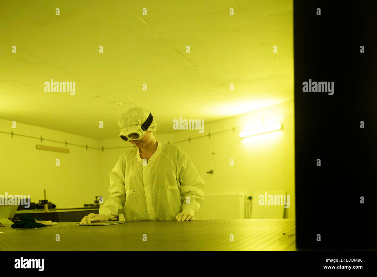Germany, Female technician working in optical clean room unit Stock ...