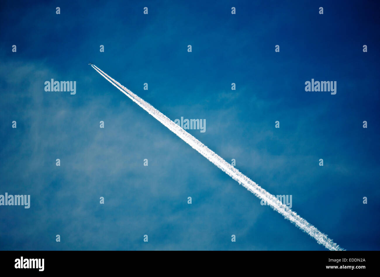 A jet contrail, a vapour trail across the sky Stock Photo - Alamy