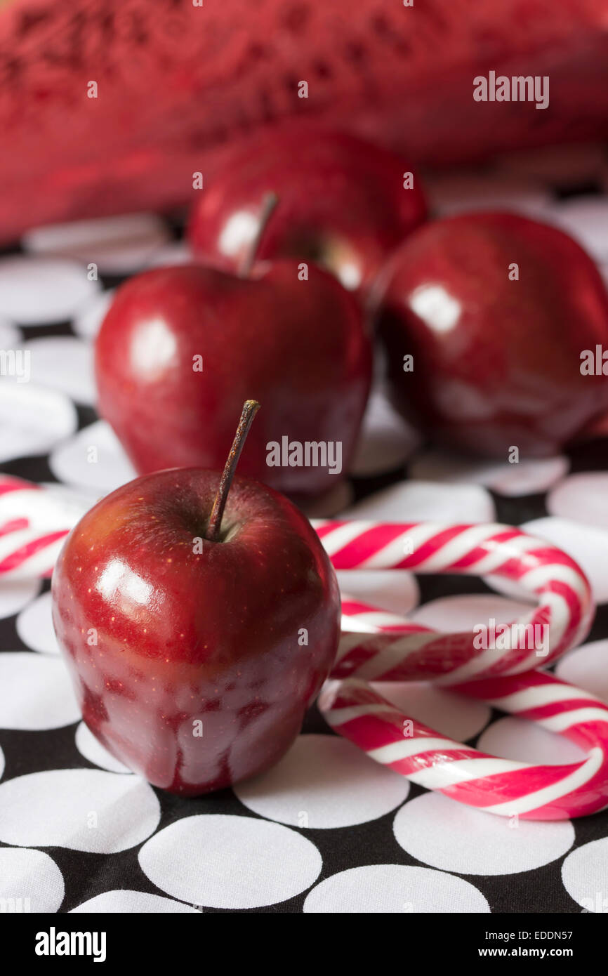 Red apples and red-white sugar canes on patterned cloth Stock Photo - Alamy