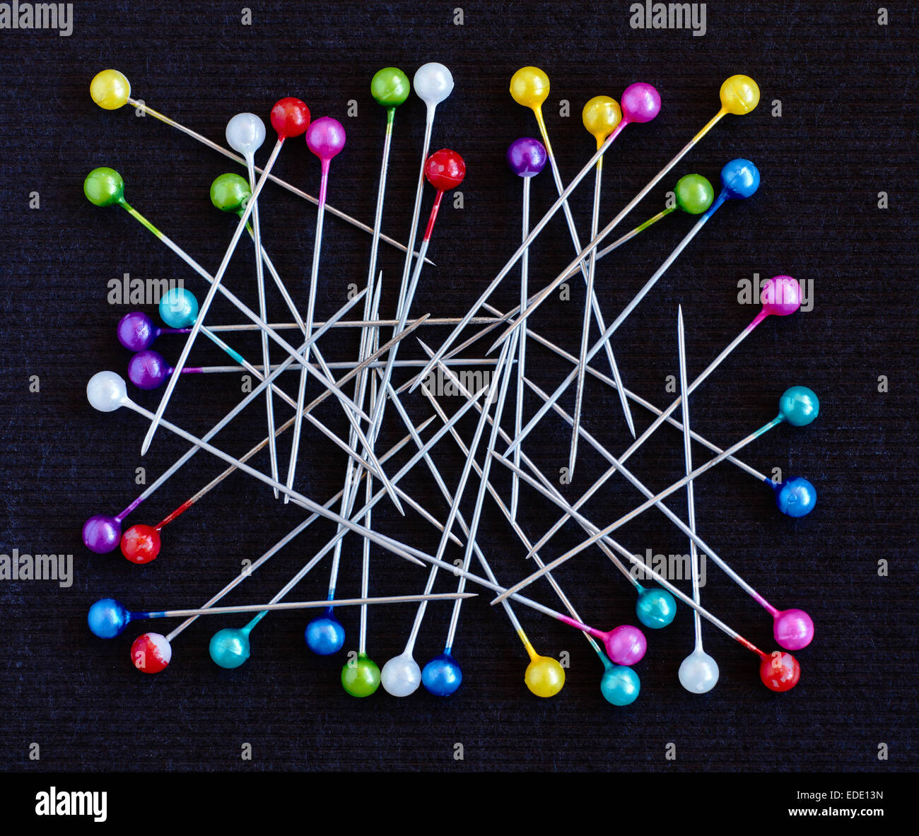 Multicolored pins lying over dark black background Stock Photo - Alamy