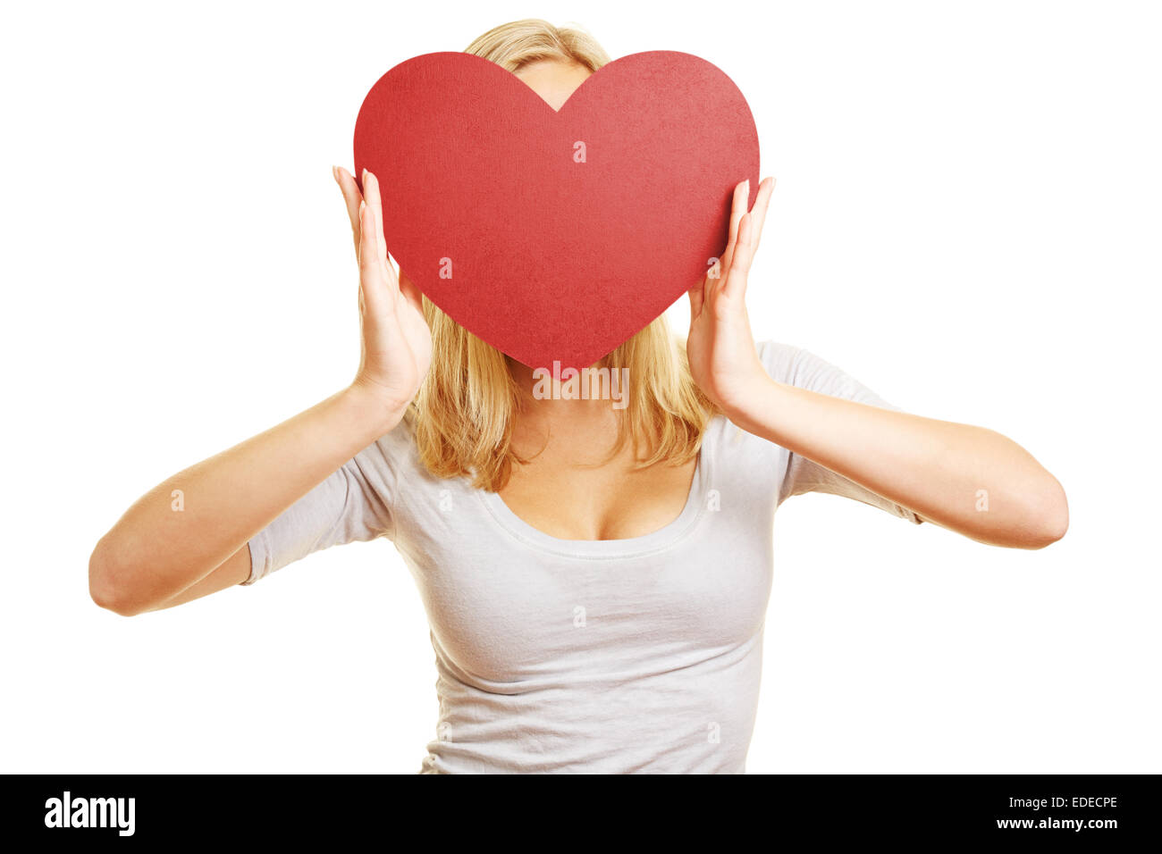 Blond woman holding a big red heart in front of her face Stock Photo ...