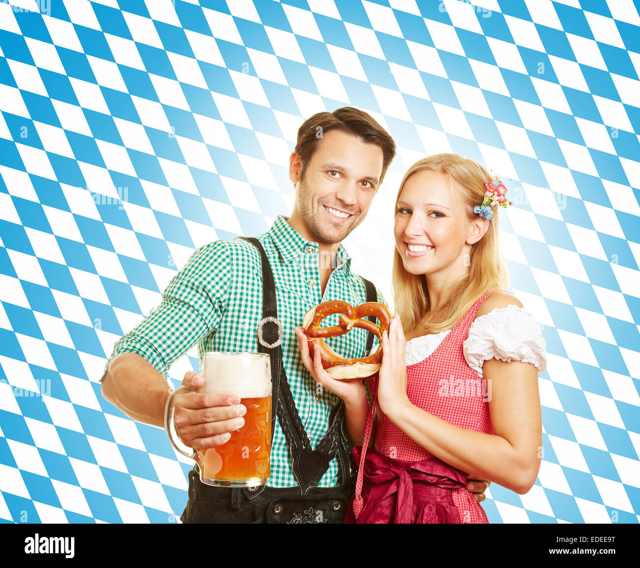 Happy couple celebrating Oktoberfest in Bavaria with beer and pretzel ...
