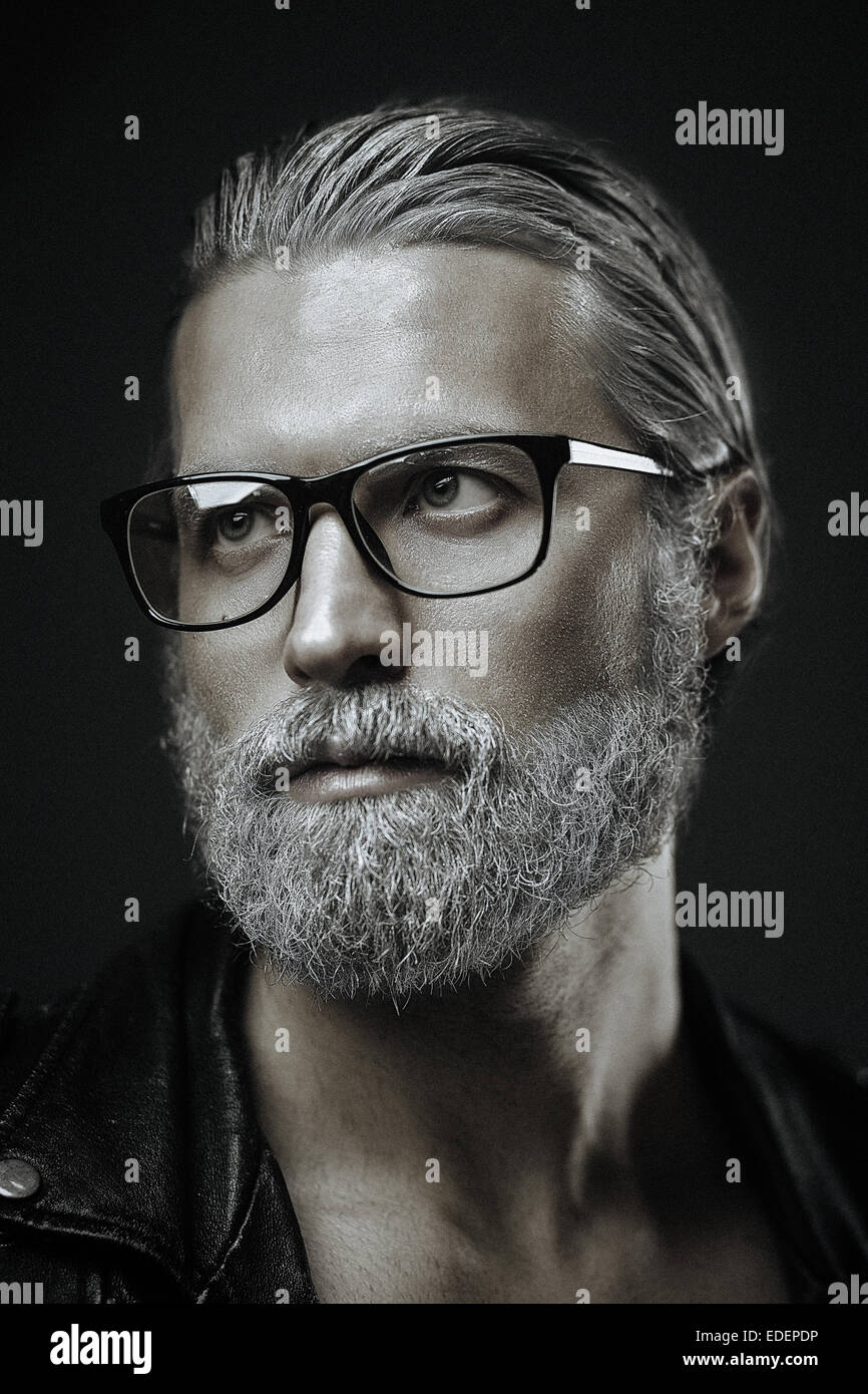Artistic portrait of gray haired man on black background. Shallow depth ...